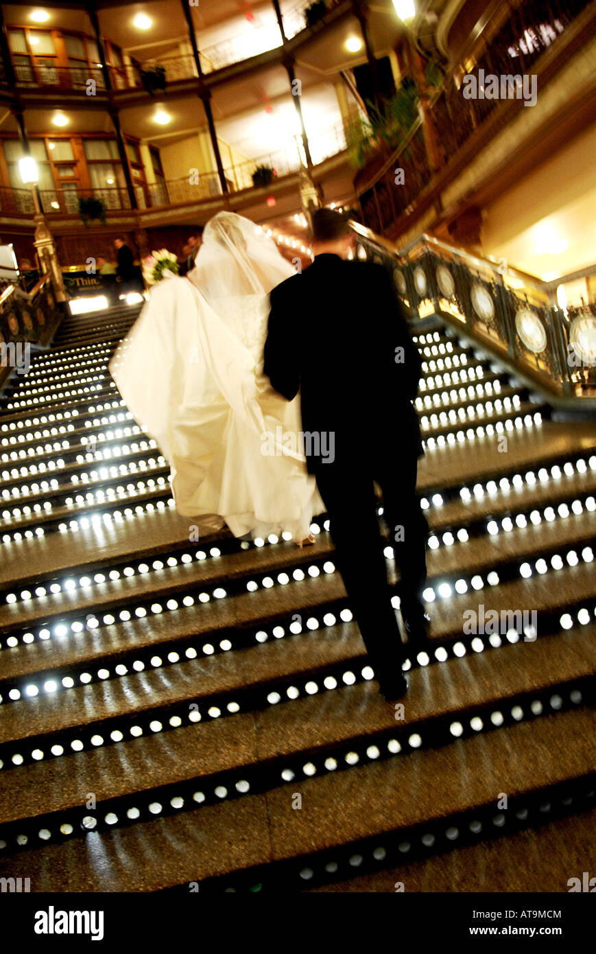 Bride and groom walk up stairwell Stock Photo - Alamy