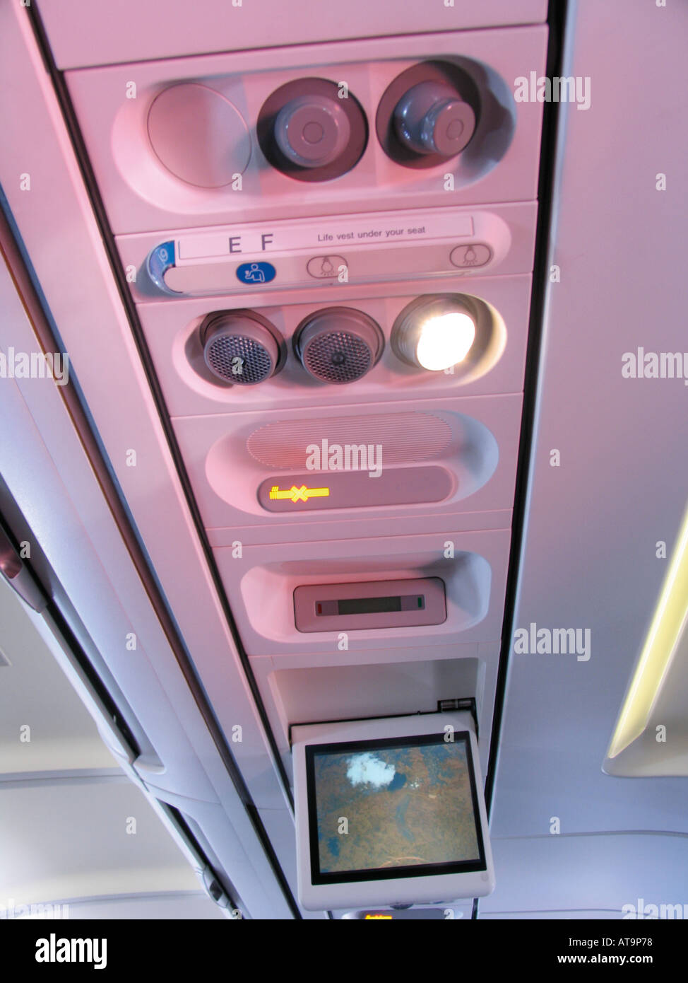 Interior of jet airliner during flight showing air controls inflight ...