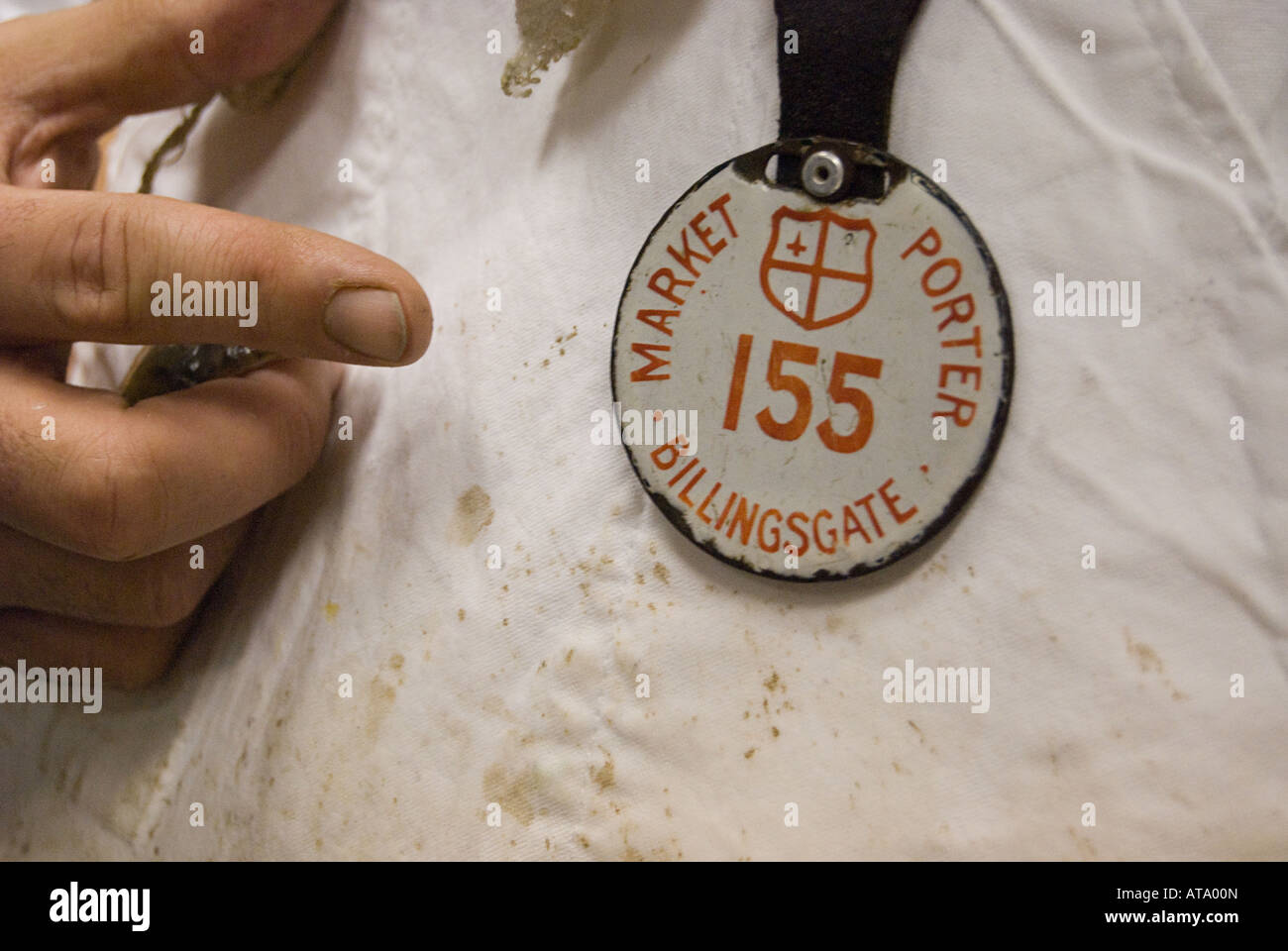 Porter pointing to his porter's badge at Billingsgate Market Stock ...