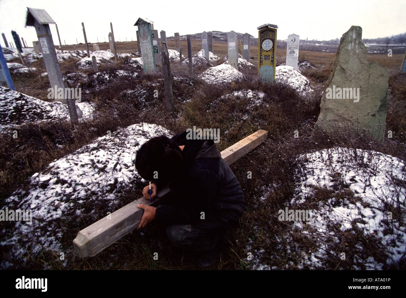 Chechen man marks his friend's grave in a cemetery near Grozny ...