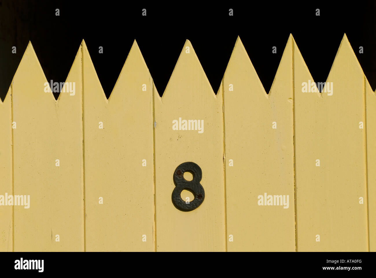 yellow painted garden gate with pointed top Stock Photo - Alamy