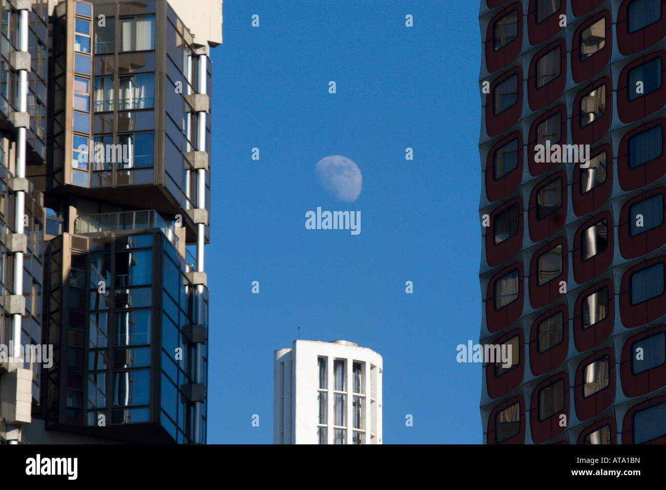 Moon visible on a winter's day between high-rise buildings in Paris ...