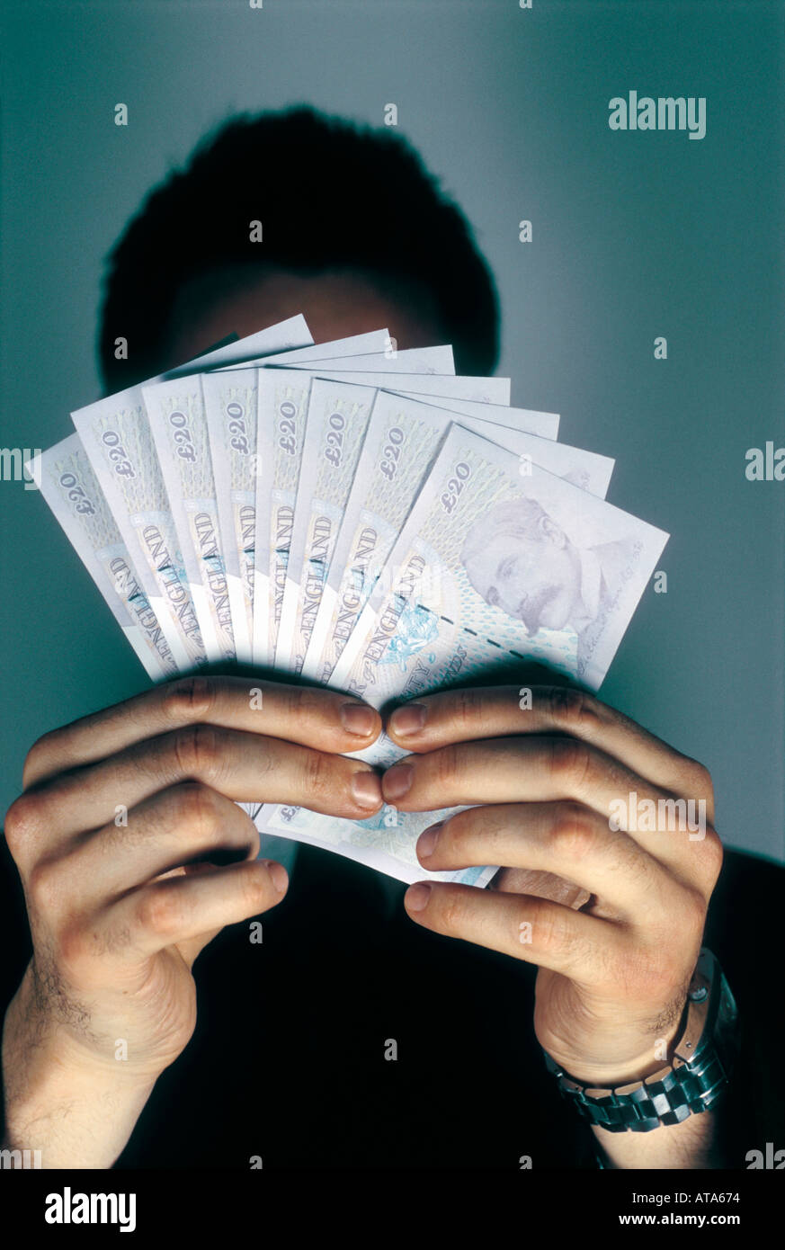 A man holding a bunch of 20 pound notes Stock Photo - Alamy