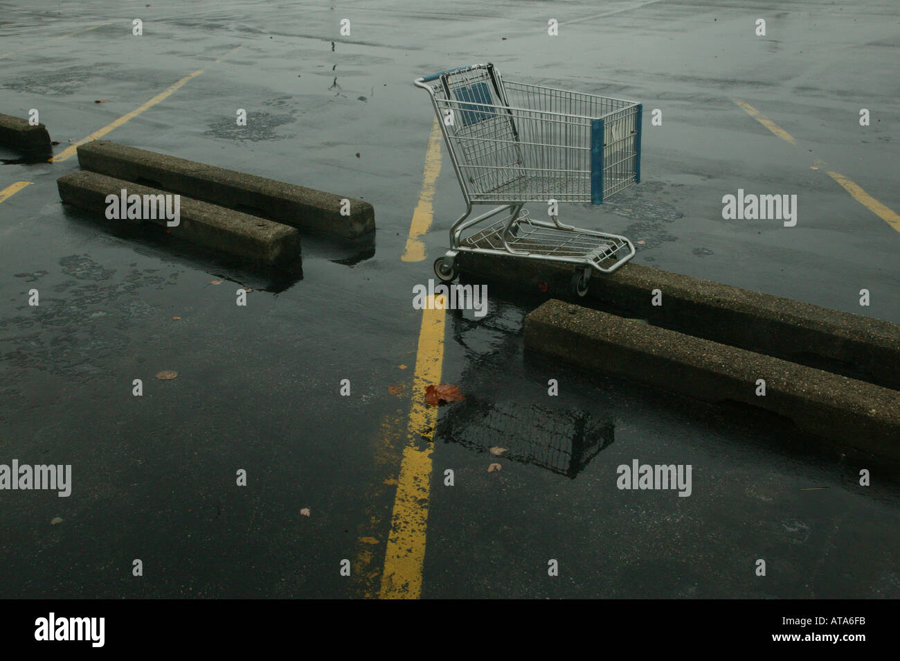A shopping cart sits abandoned in a strip mall parking lot Stock Photo ...