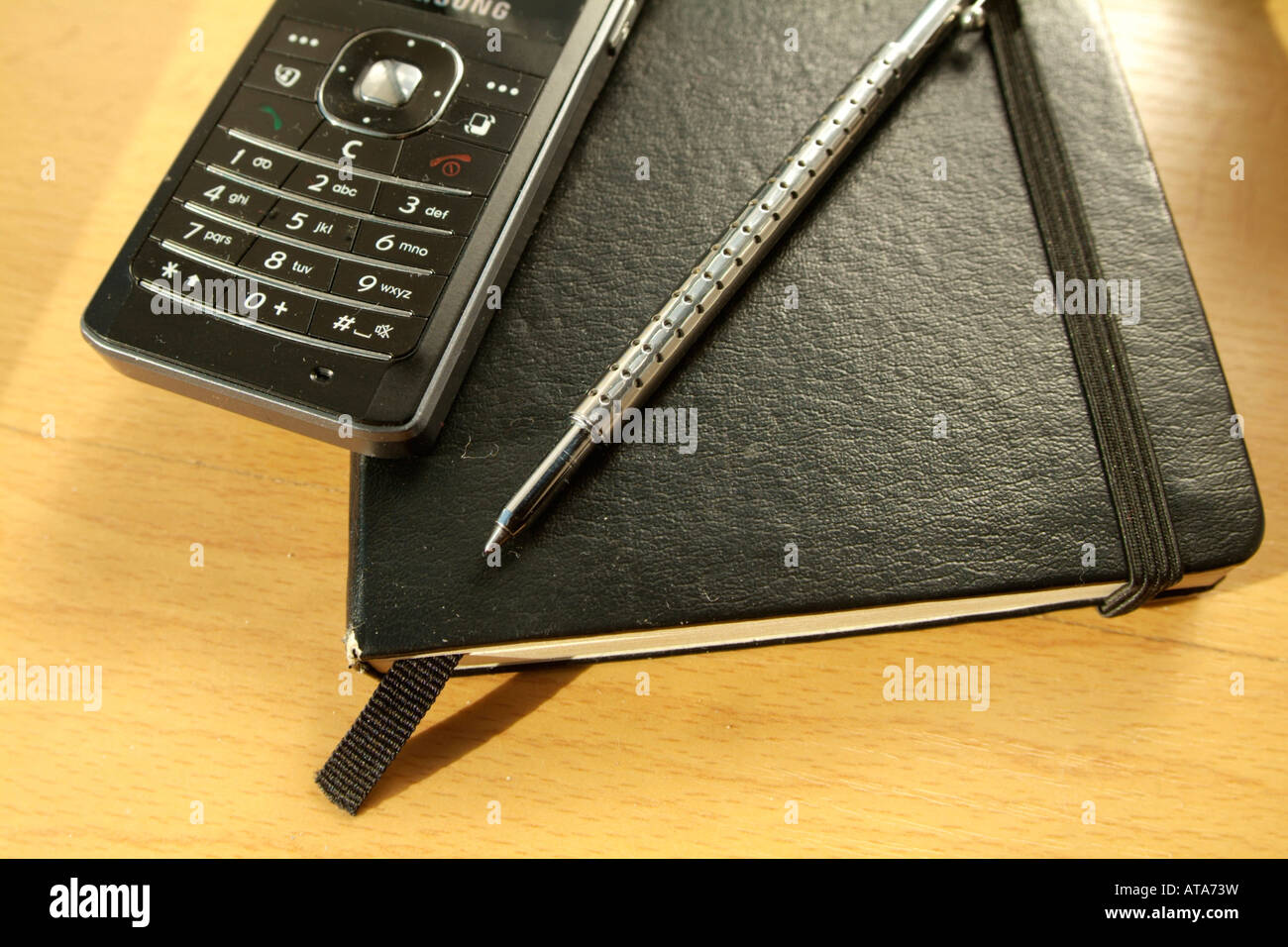Mobile phone and notebook Stock Photo - Alamy