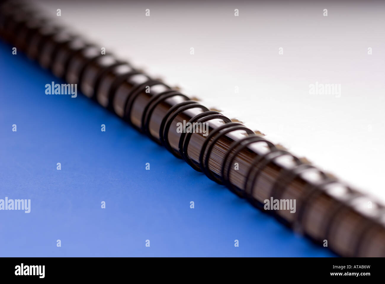 macro of a white spiral ring bound document on a blue background Stock ...