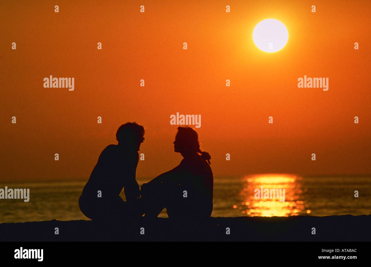 Silhouette of couple on the beach at sunset Stock Photo - Alamy