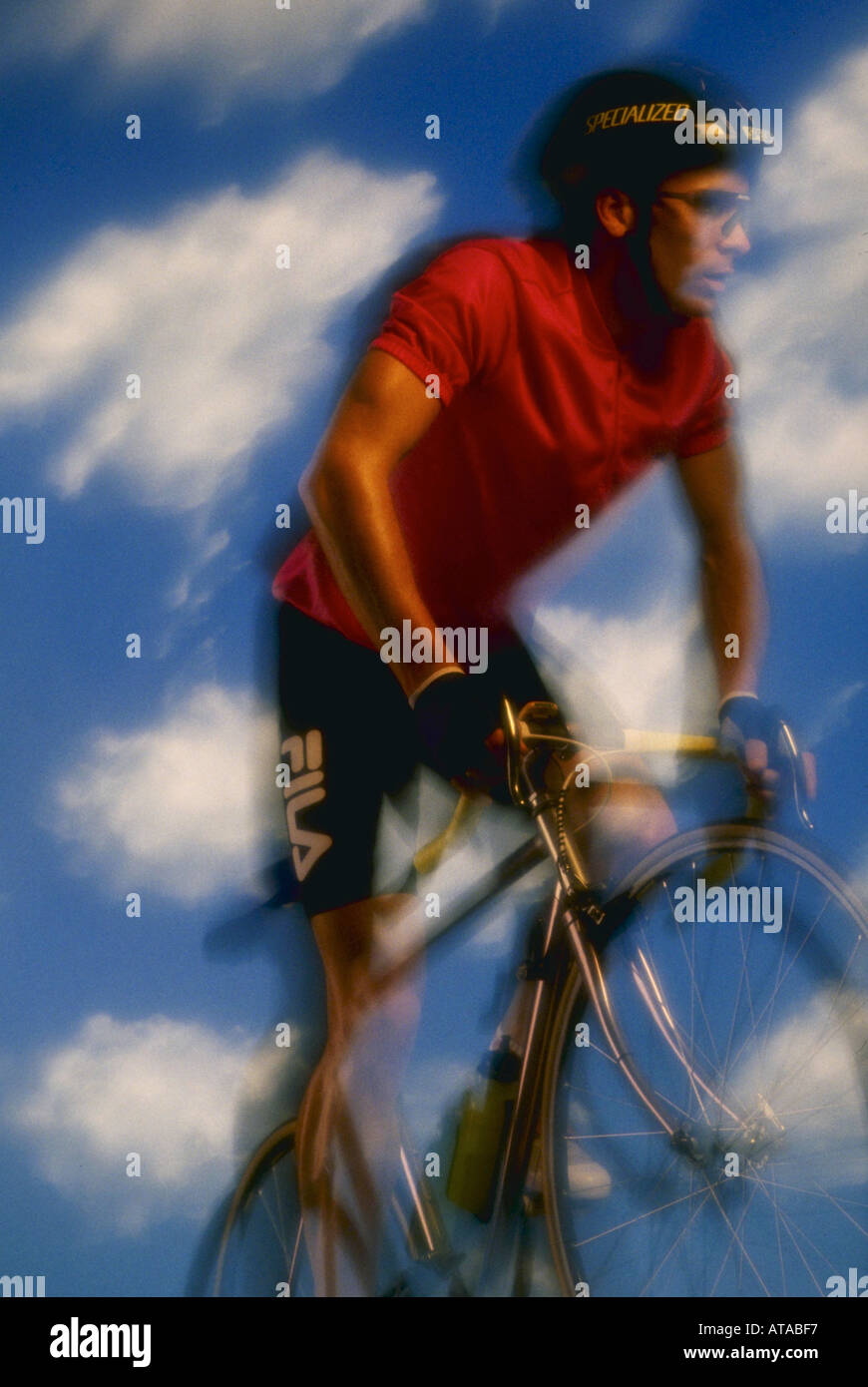 Man riding bicycle with blue sky and clouds Stock Photo - Alamy