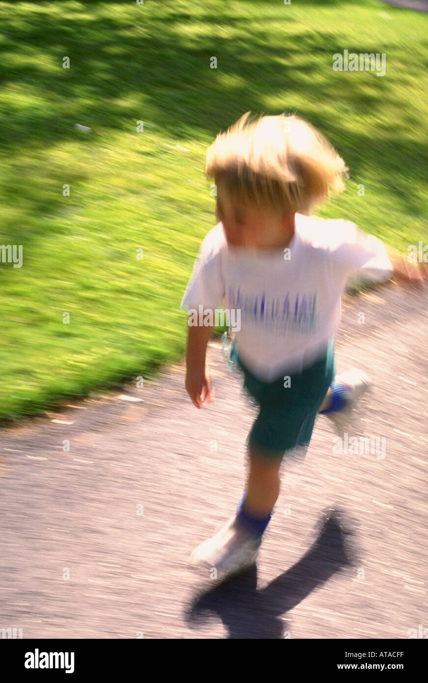 Young boy running on sidewalk Stock Photo - Alamy