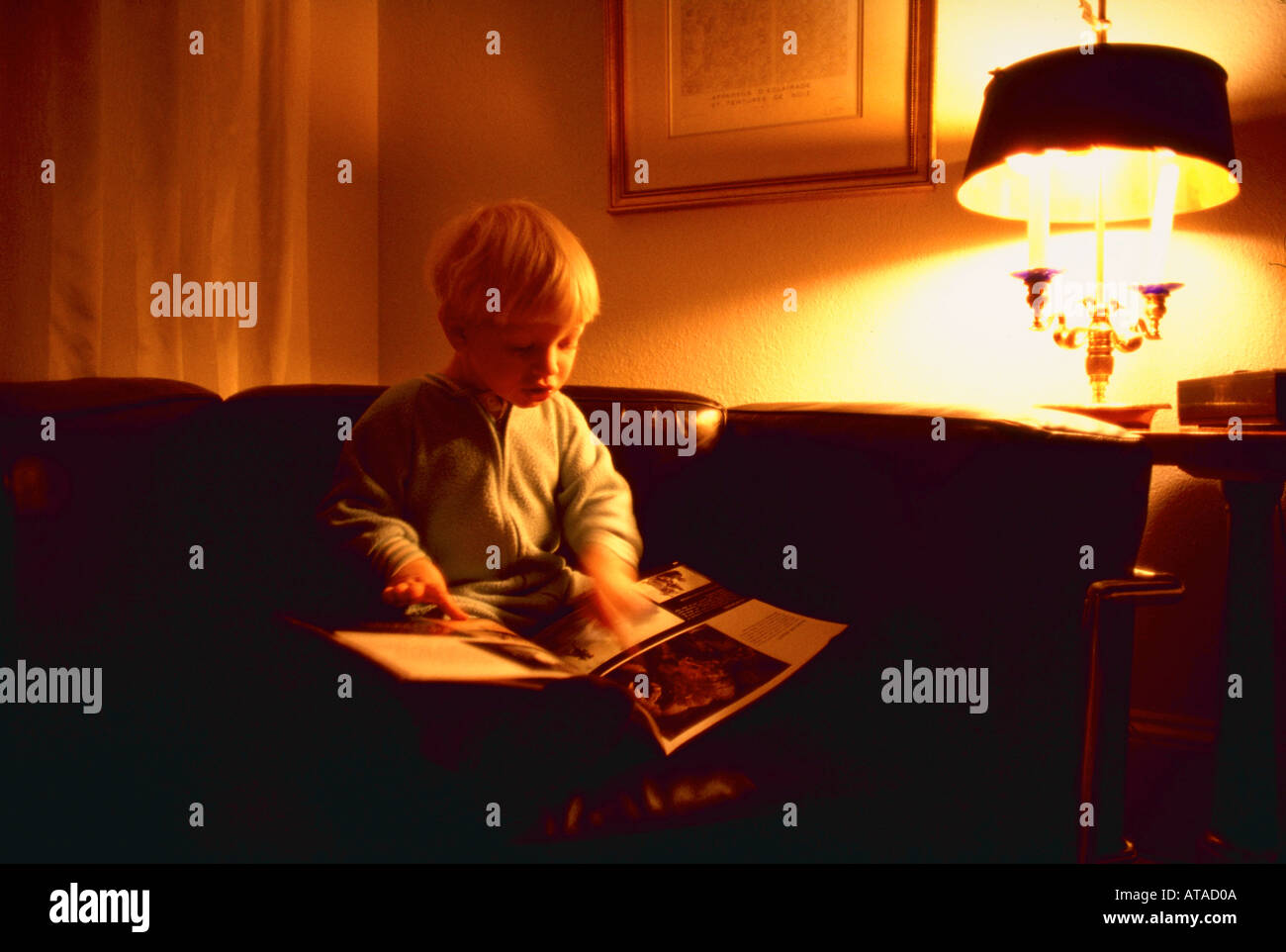 Young boy in pajamas reading book before bed Stock Photo - Alamy