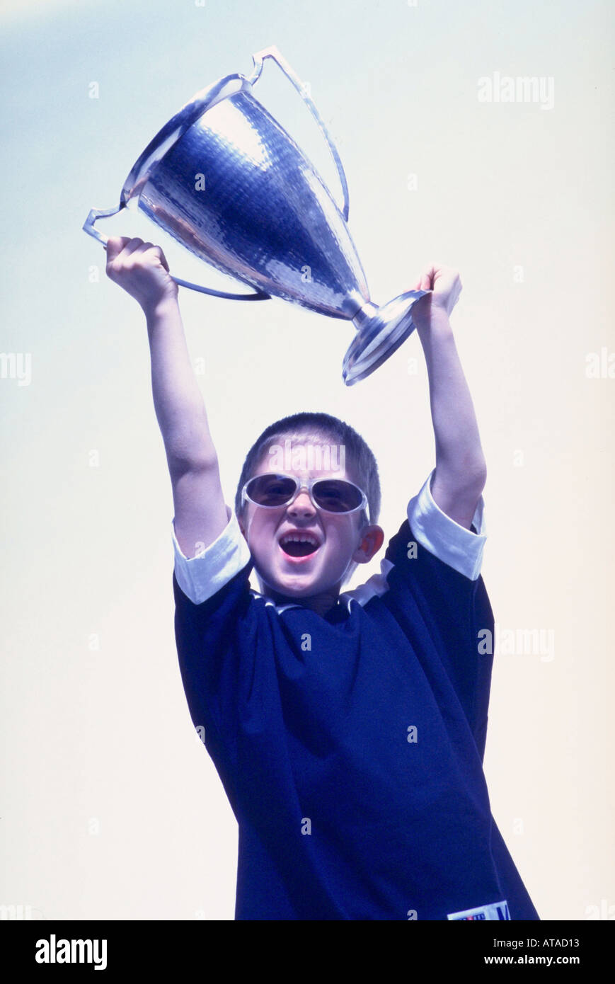 Young boy holding trophy cup Stock Photo - Alamy