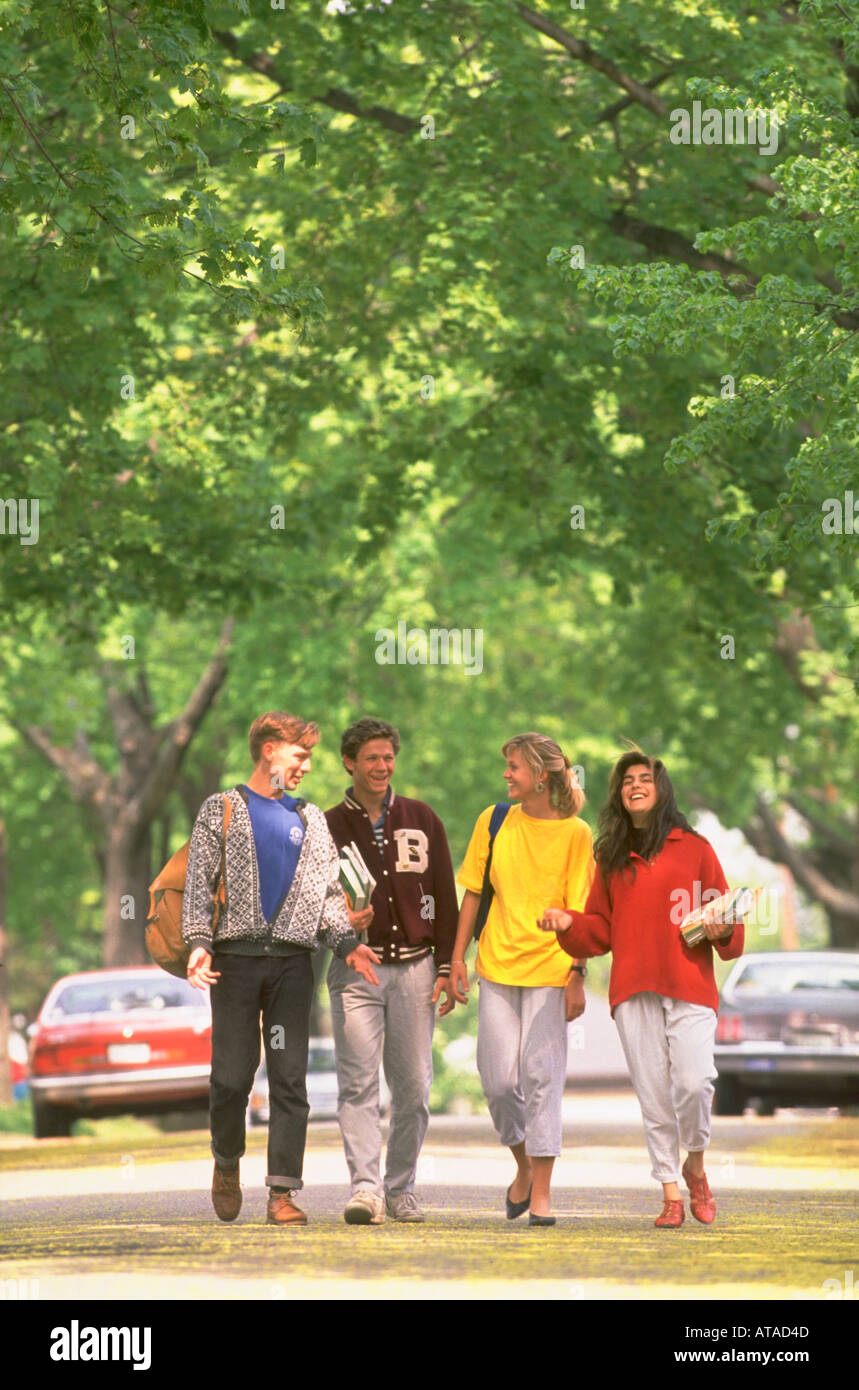 Four college students walking on campus Stock Photo - Alamy