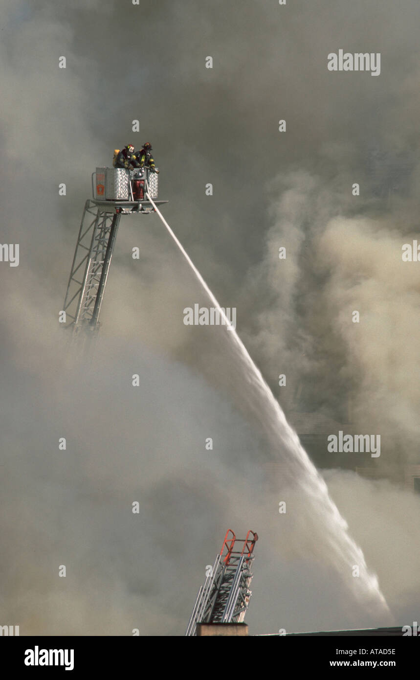 Firefighters using hose among clouds of smoke Stock Photo - Alamy