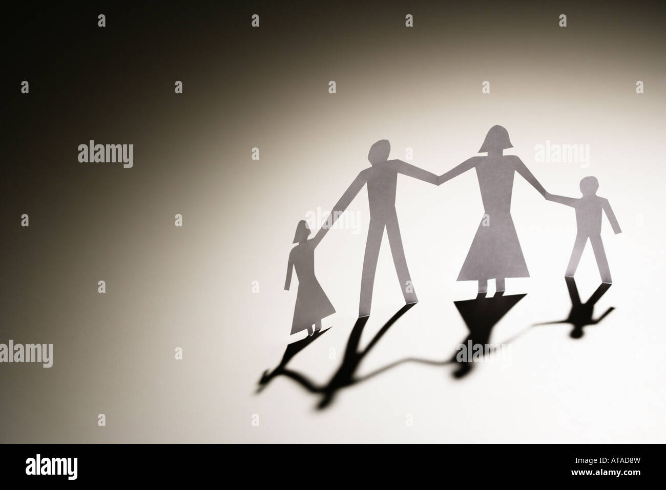 Paper cutout family of four standing holding hands Stock Photo - Alamy