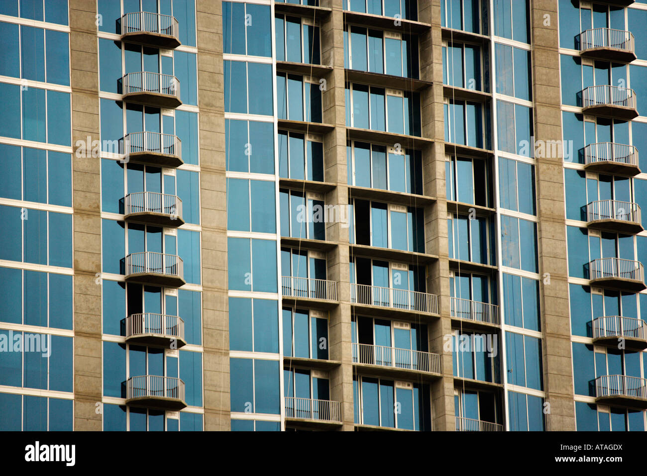 Exterior of high rise building with mirrored windows and balconies ...