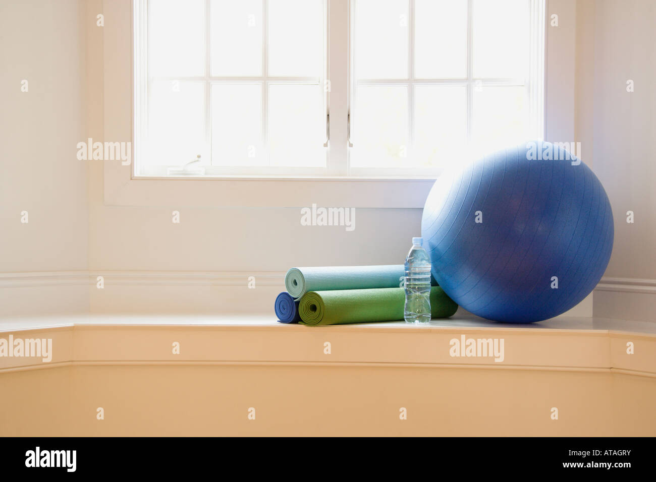 Balance ball exercise mats and bottled water at gym by window Stock ...