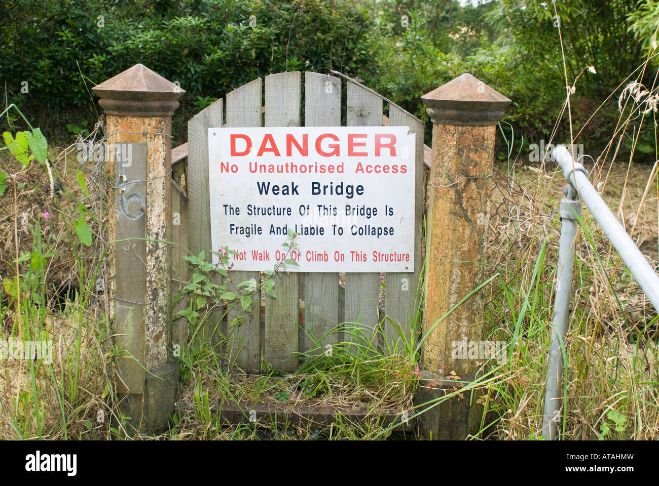 Gateway to a disused bridge displaying warning sign as to dangerous ...