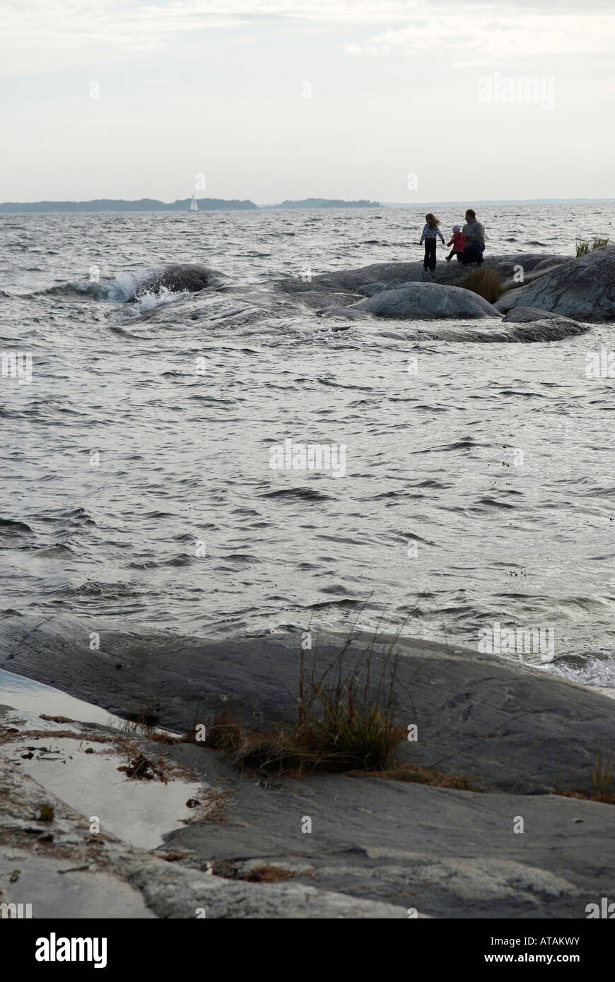 Two kids and a man on a rock overlooking the sea Bjorno Stockholms Lan ...