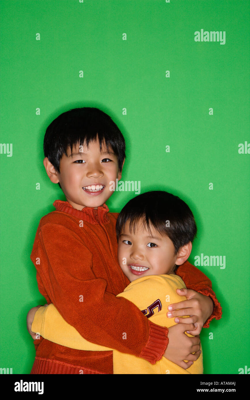 Young Asian brothers hugging eachother smiling Stock Photo - Alamy