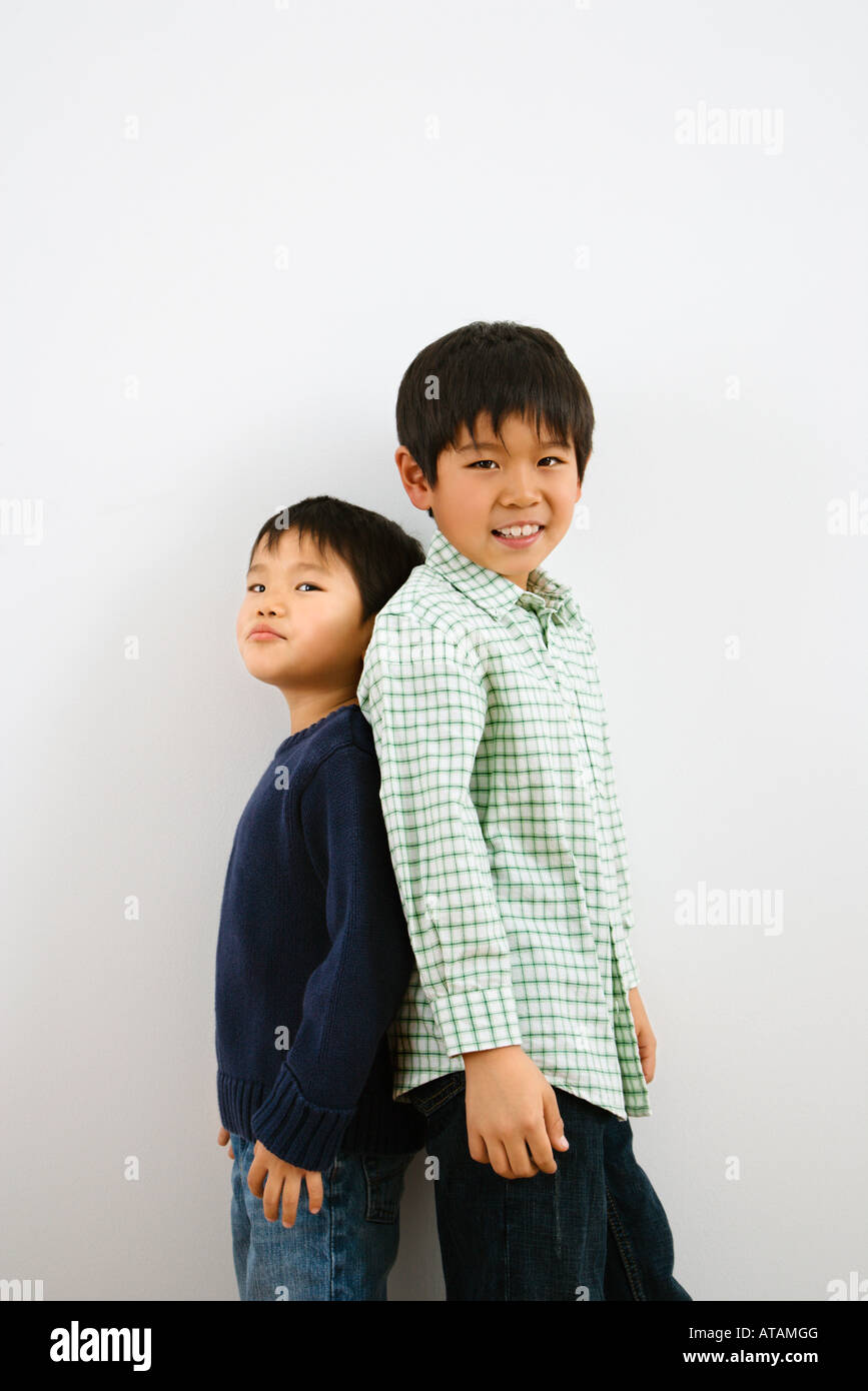 Two young Asian brothers standing back to back Stock Photo - Alamy