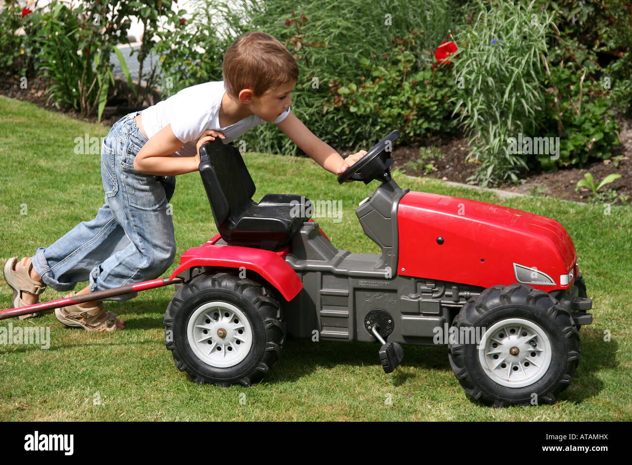 Child with tractor in the garden Stock Photo - Alamy