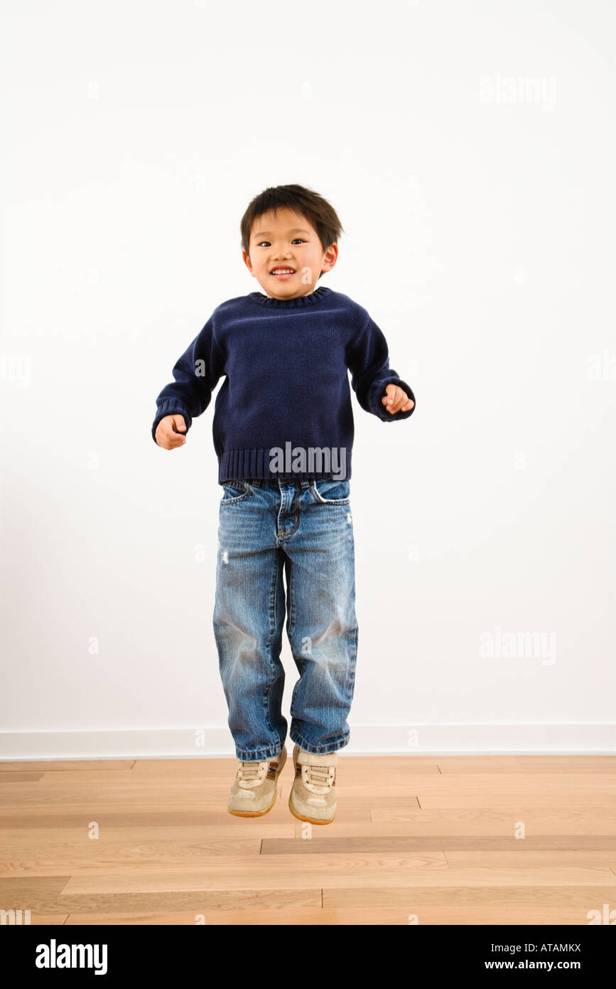 Young Asian boy jumping up into air smiling Stock Photo - Alamy