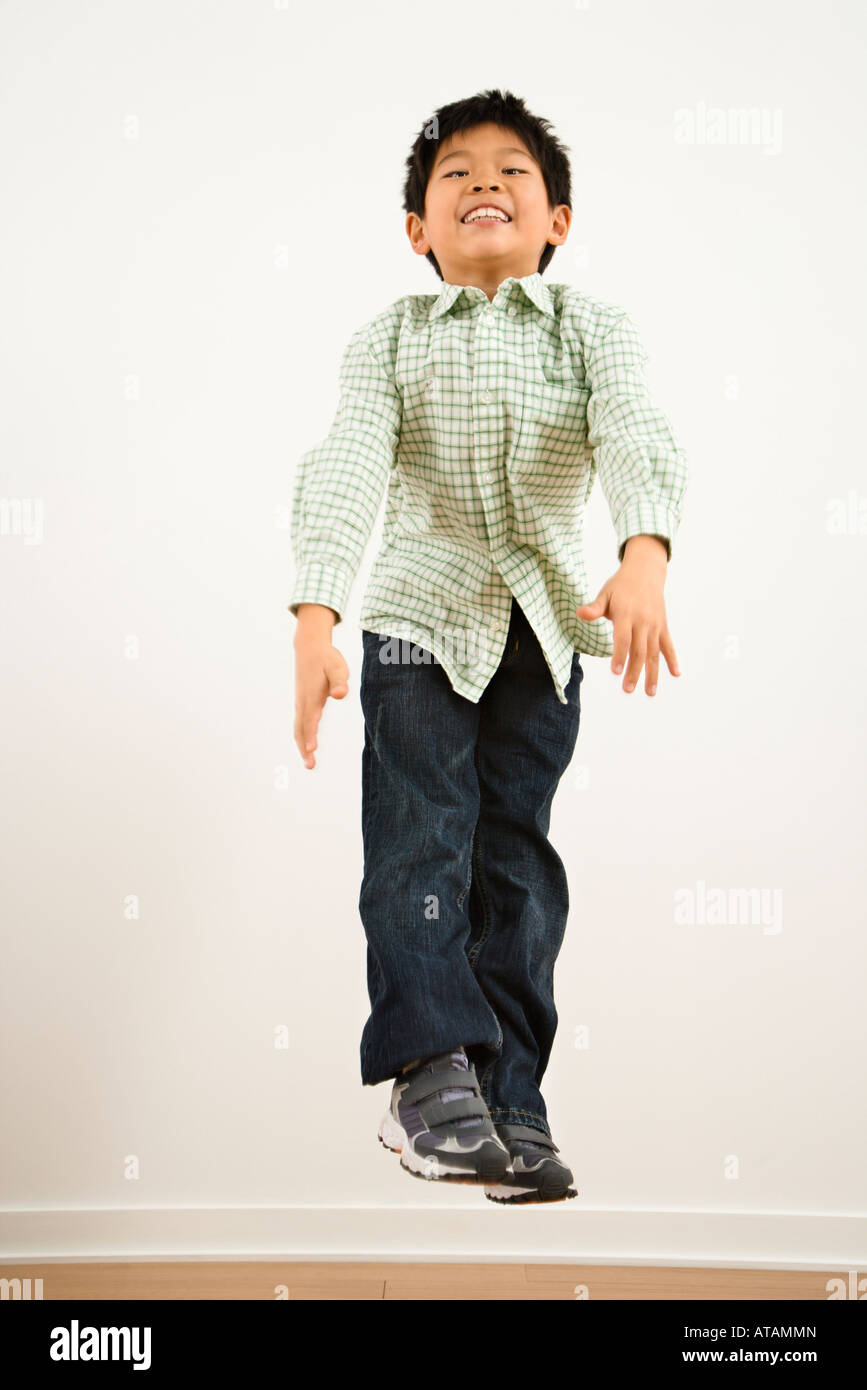 Young Asian boy jumping up into air smiling Stock Photo - Alamy