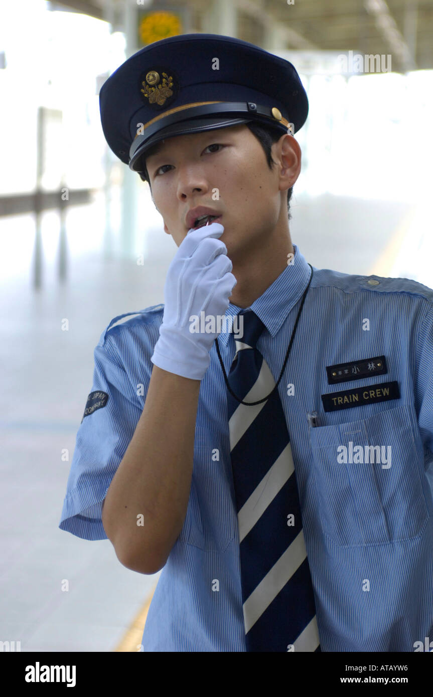 Train operator blowing a whistle to clear the train for leaving the ...