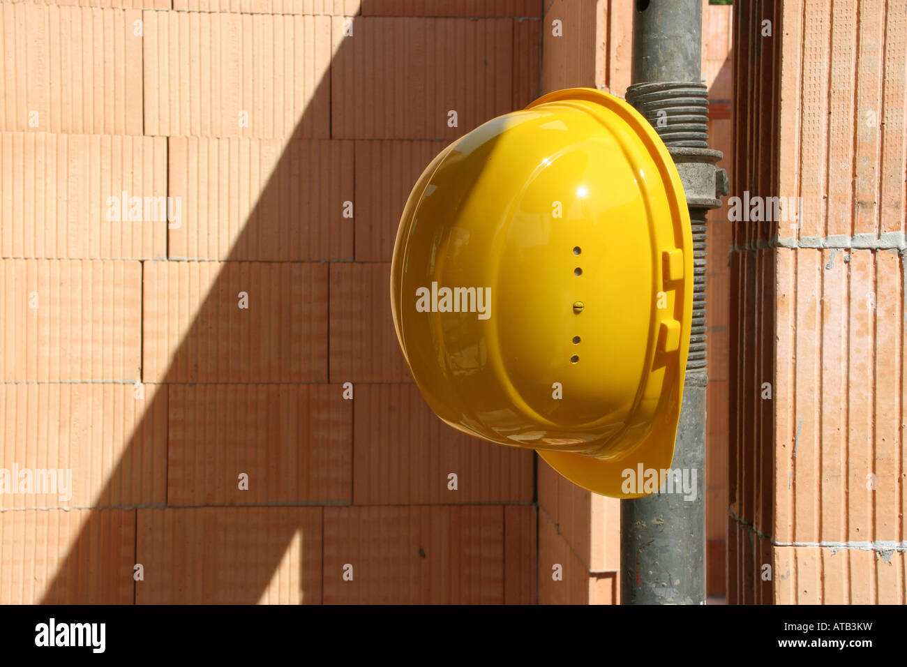 yellow work helmet on a building site Stock Photo - Alamy