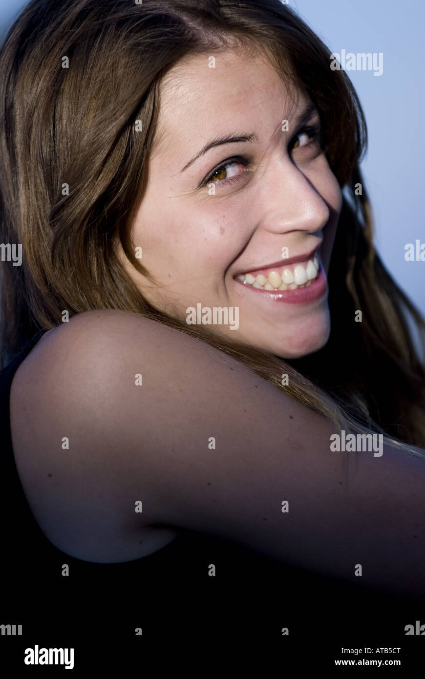 cute young longhaired woman smiling roguishly Stock Photo - Alamy