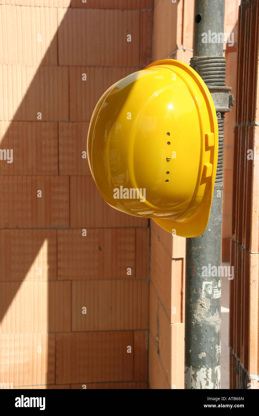 yellow work helmet on a building site Stock Photo - Alamy