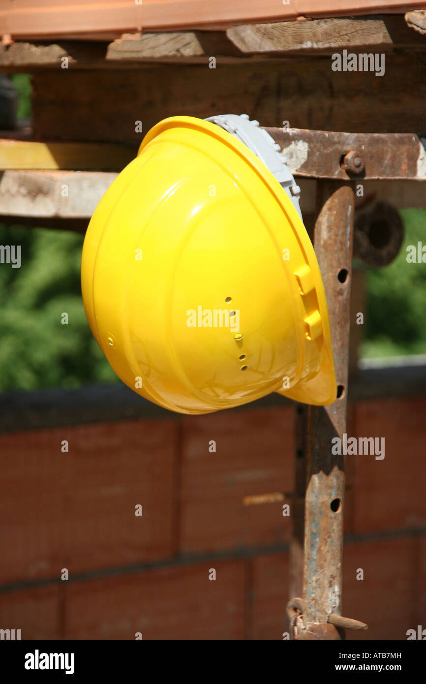 yellow work helmet on a building site Stock Photo - Alamy