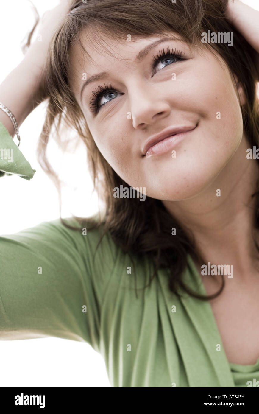young woman looking up and grasping her hair Stock Photo - Alamy
