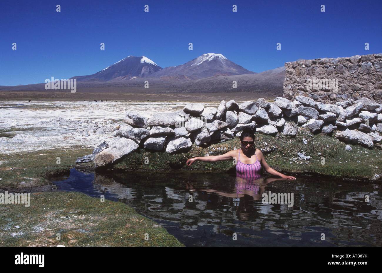 Hispanic girl relaxing in the hot springs, Payachatas volcanoes in ...