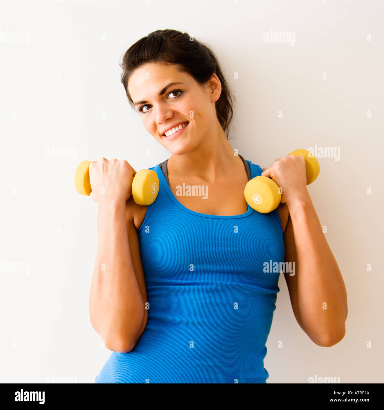 Woman holding hand weights and smiling Stock Photo - Alamy