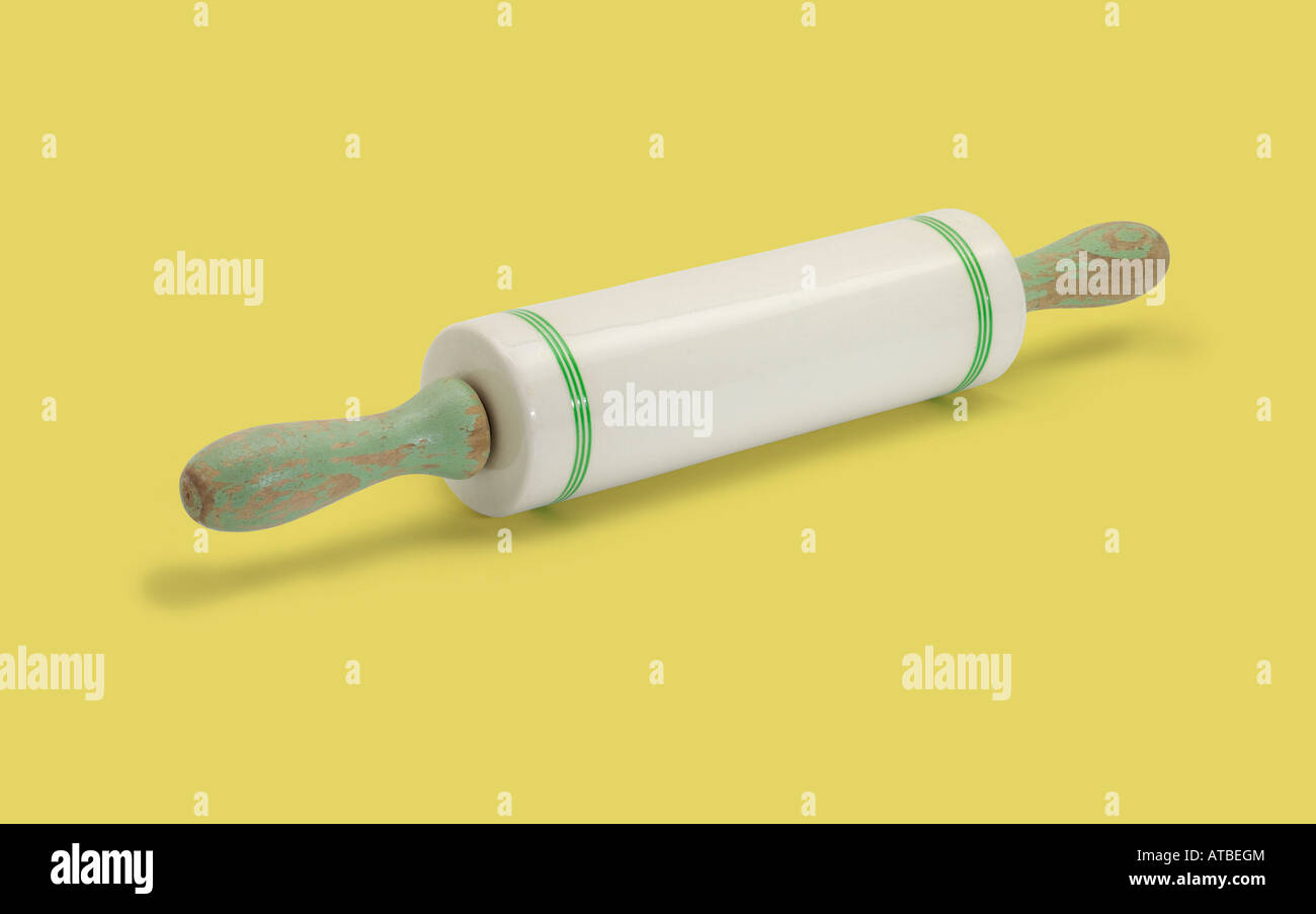old style rolling pin on yellow background Stock Photo - Alamy