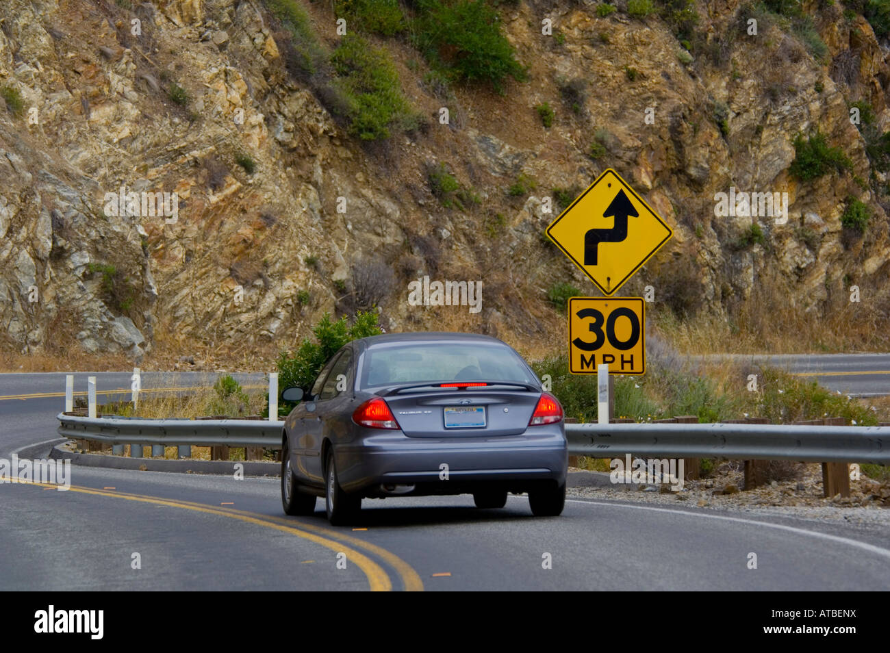 Car and speed saftey warning sign on curve along Highway One 1Big Sur ...
