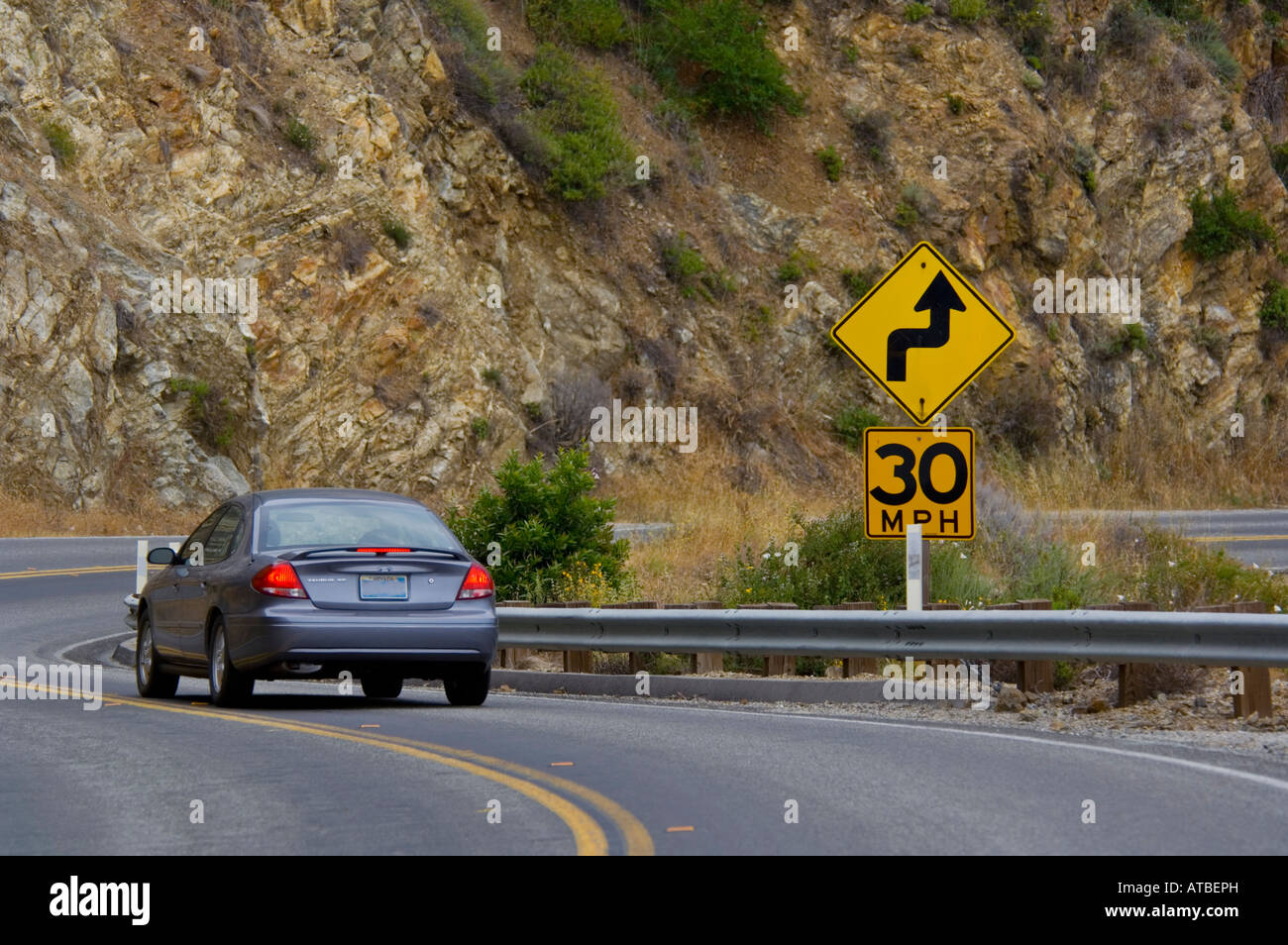 Car and speed saftey warning sign on curve along Highway One 1Big Sur ...