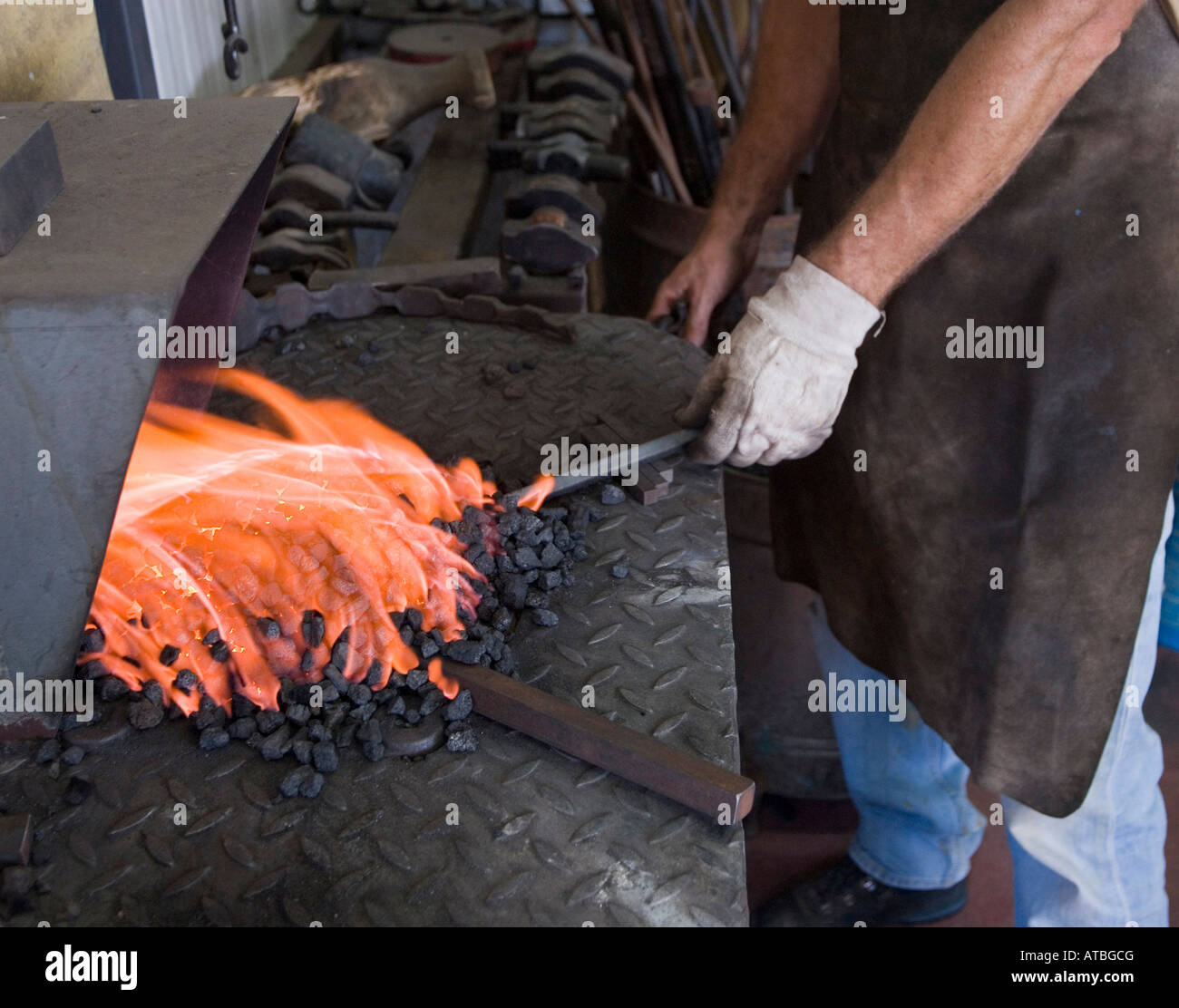Old style hand made iron workers in a small work shop heating the iron ...