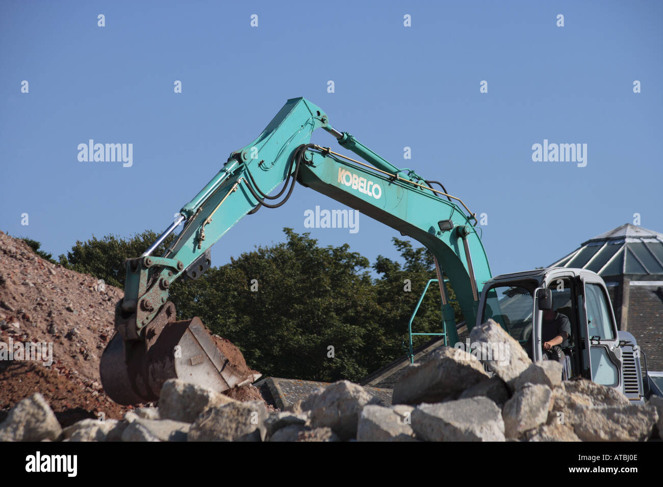 Turquoise Mechanical digger at work Stock Photo - Alamy