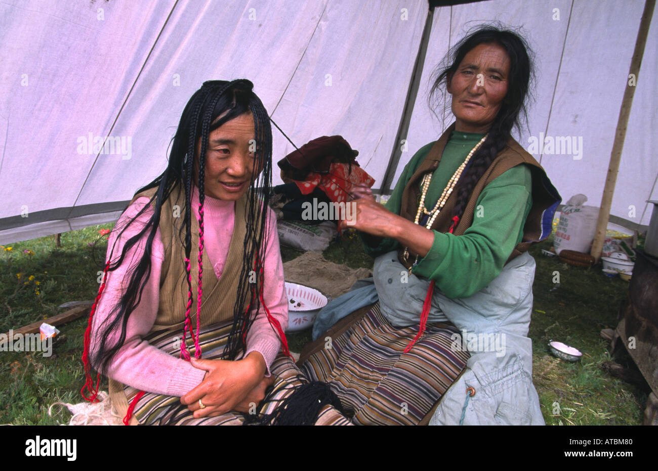 Khampa woman braiding her hair in 108 strands-an auspicious Tibetan ...