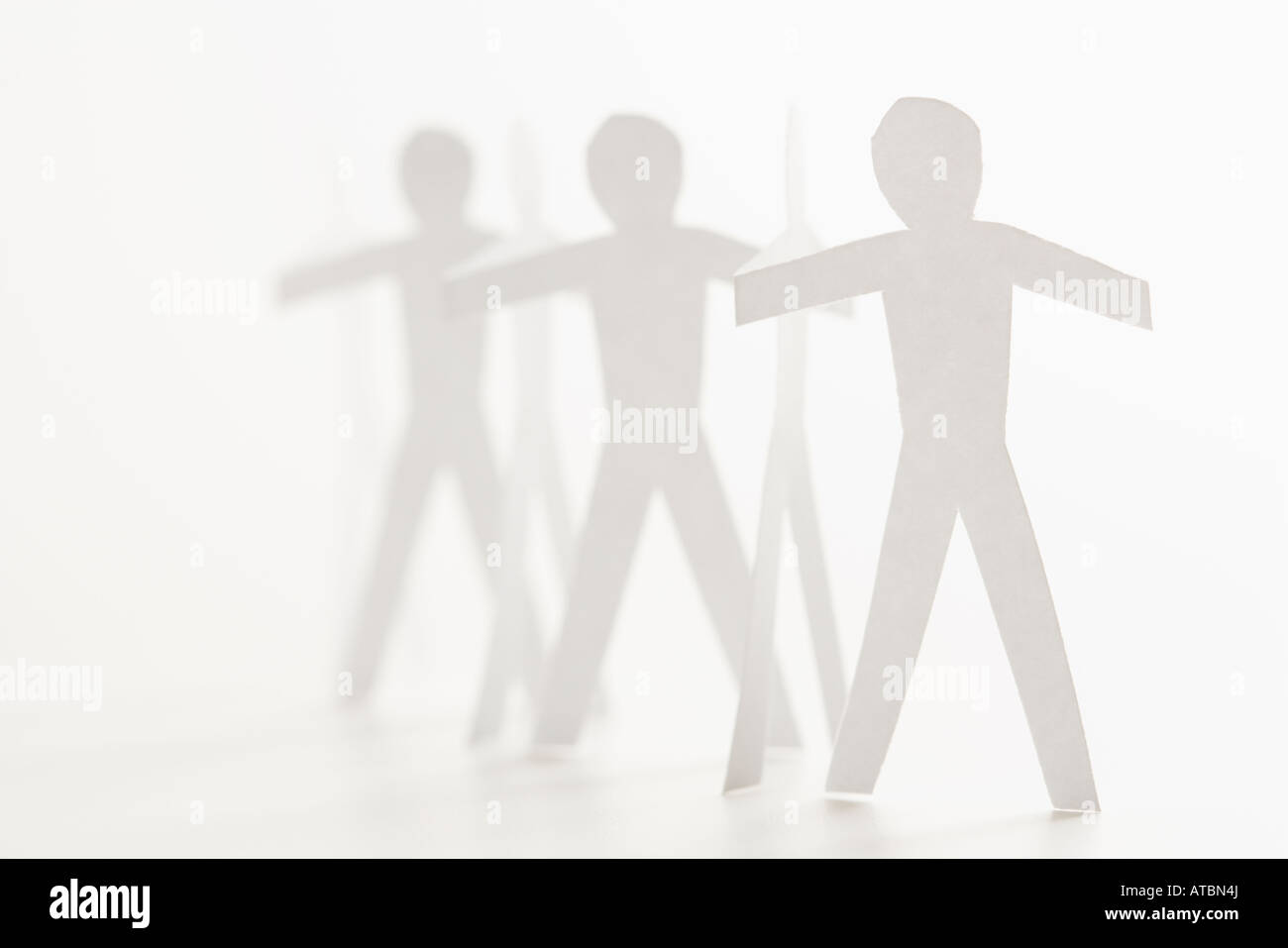 Cutout paper men standing holding hands Stock Photo - Alamy