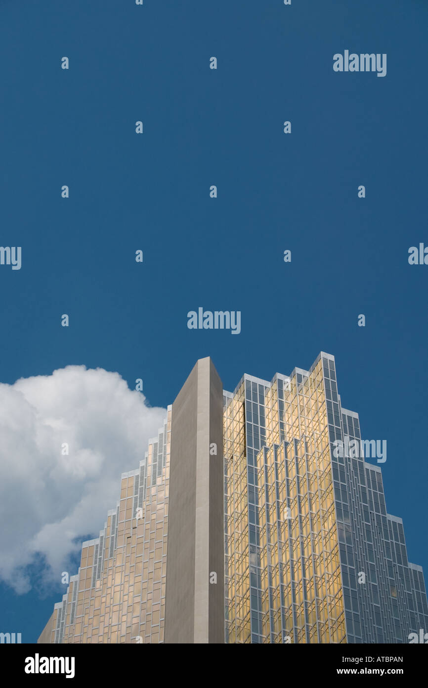 A Golden mirrored skyscraper against a blue sky background with white ...