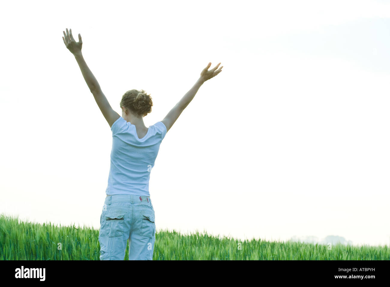 Teenage girl standing with arms raised, rear view Stock Photo - Alamy