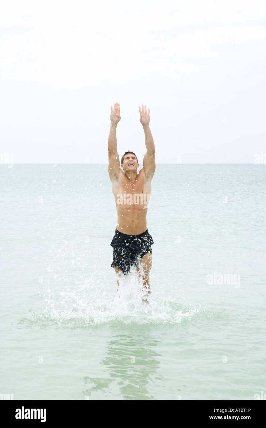 Man splashing in water, arms raised, head back Stock Photo - Alamy