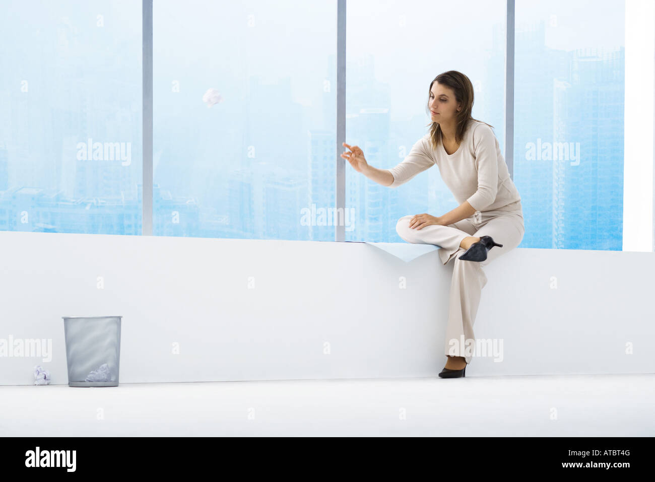 Woman throwing paper ball toward trash can Stock Photo - Alamy