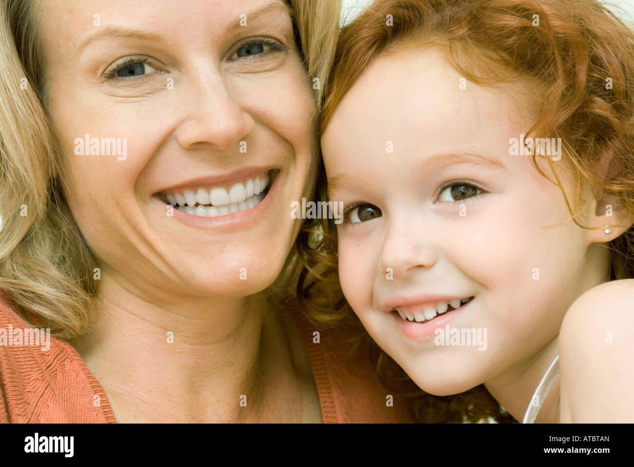 Mother and daughter cheek to cheek, smiling at camera, portrait Stock ...
