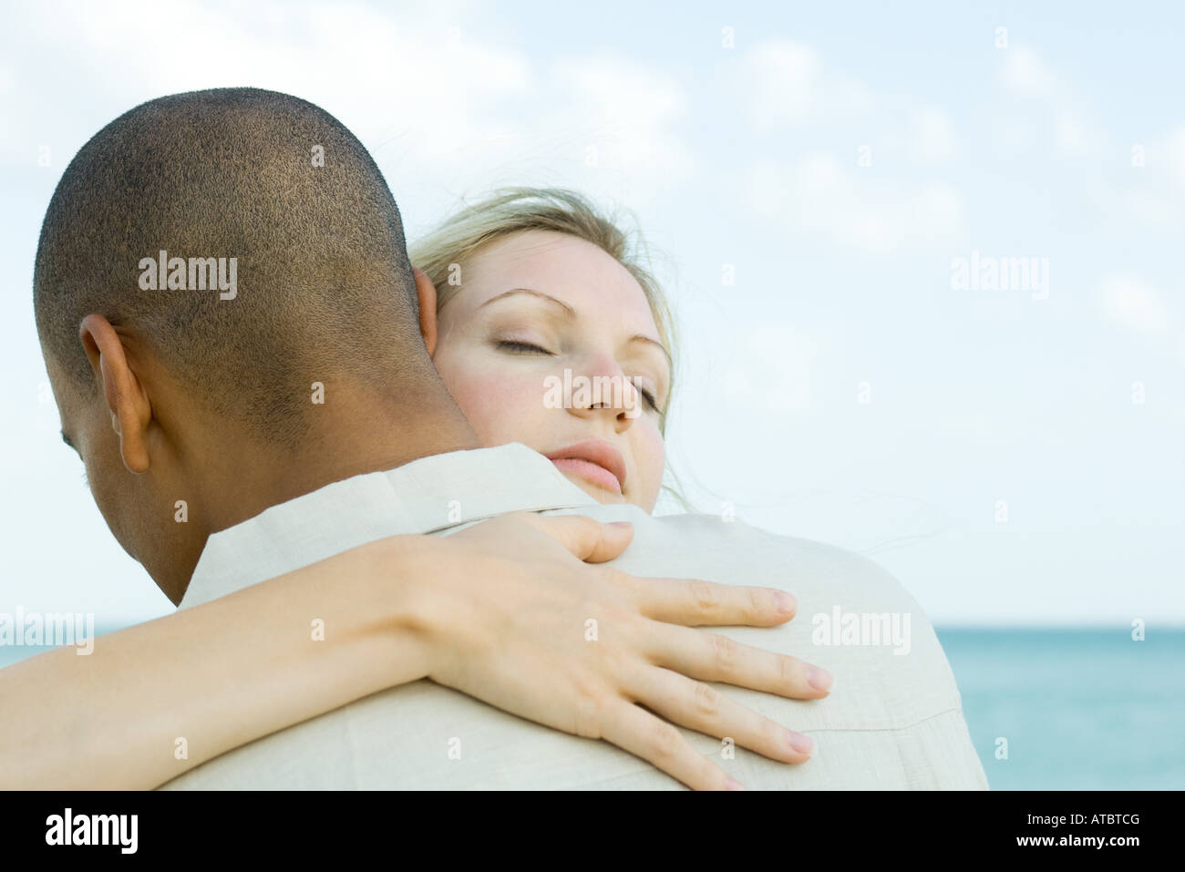Couple embracing, woman's eyes closed, rear view Stock Photo - Alamy