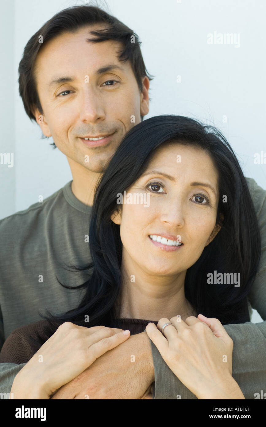 Couple embracing, both smiling at camera, portrait Stock Photo - Alamy