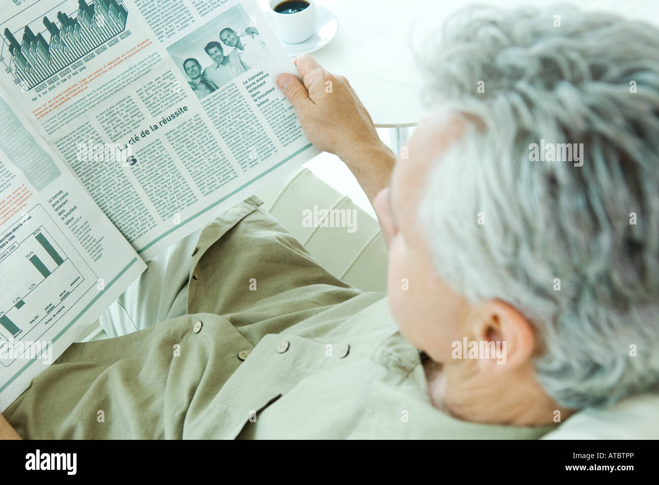 Mature man reading newspaper, over the shoulder view Stock Photo - Alamy